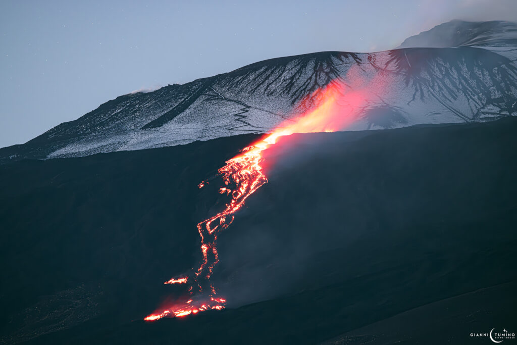 Lo spettacolo della colata lavica sull’Etna imbiancata dalla grandine